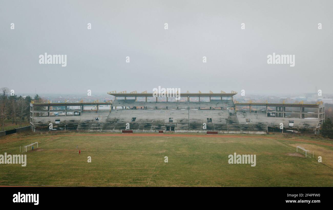 Aerial shot of an old football stadium with children playing with a ...