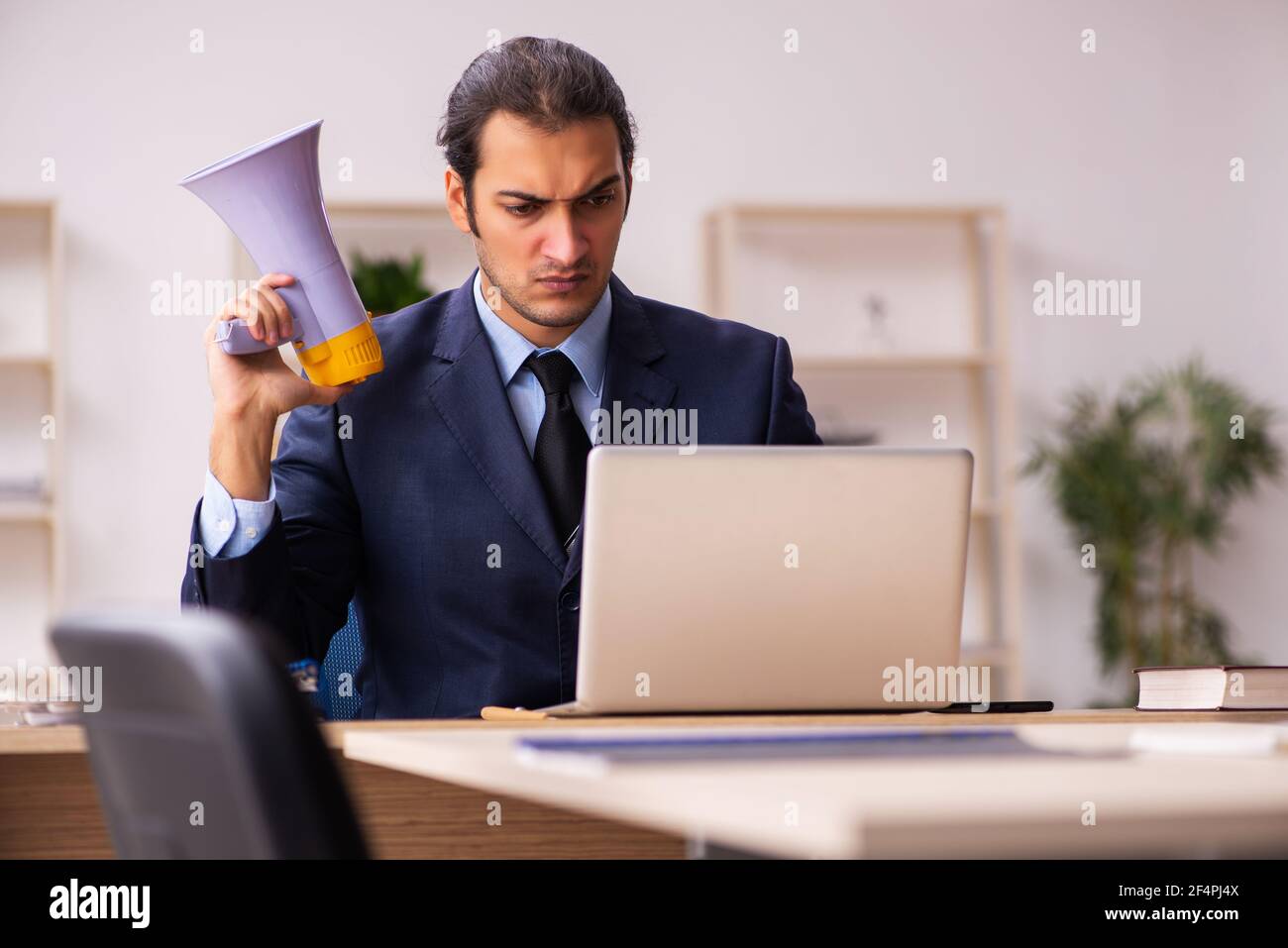 Young businessman employer holding megaphone in the office Stock Photo ...