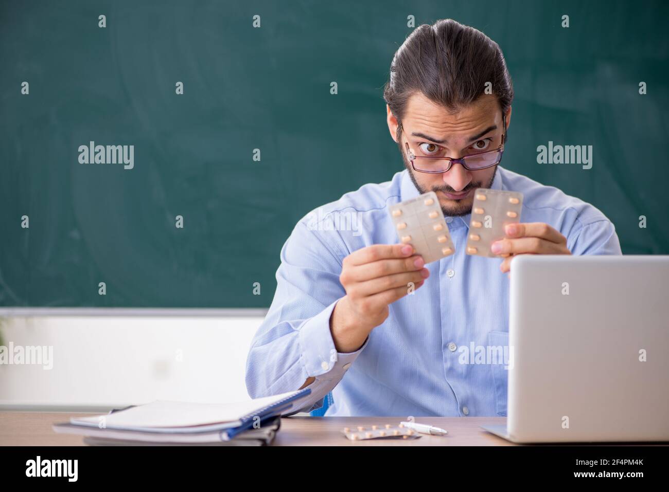 Young sick teacher in the classroom Stock Photo - Alamy
