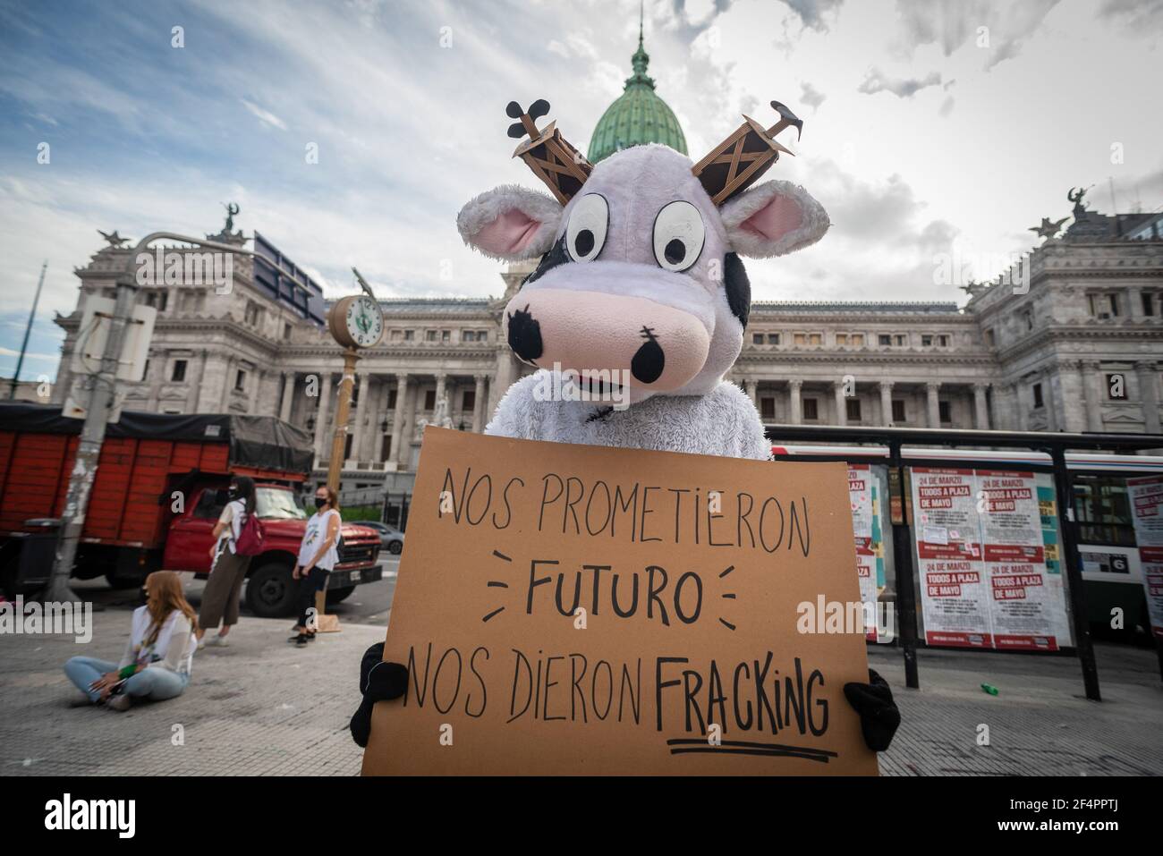 A protester dressed as cow holds a placard that says They promised us a ...