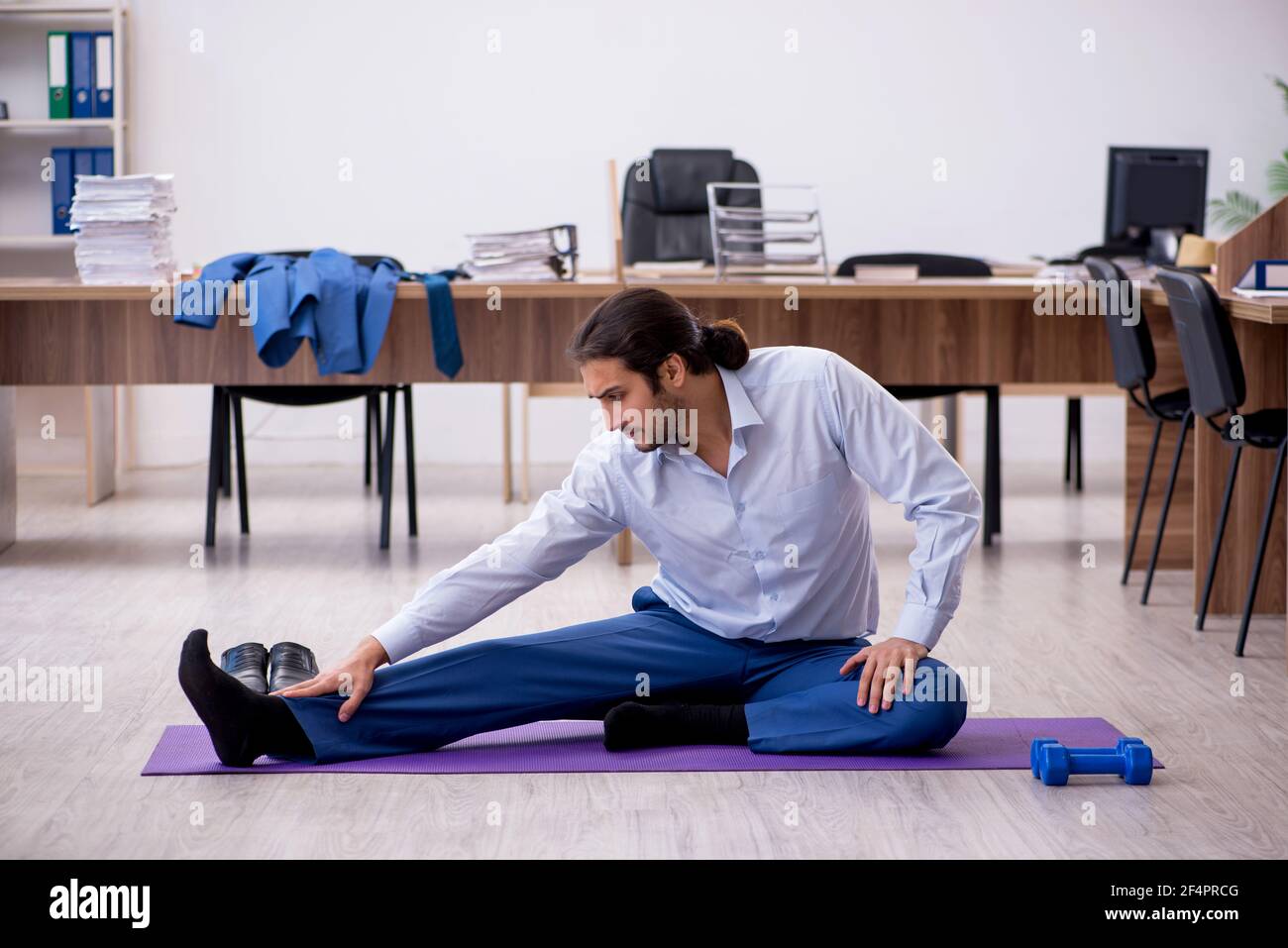 Young employee doing sport exercises during break Stock Photo - Alamy