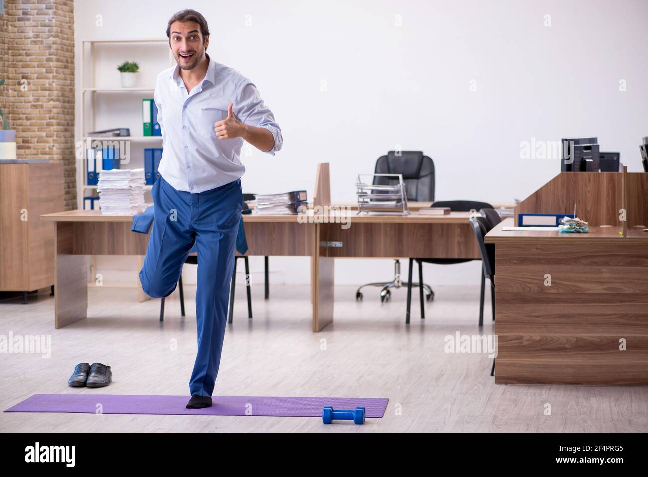 Young employee doing sport exercises during break Stock Photo - Alamy