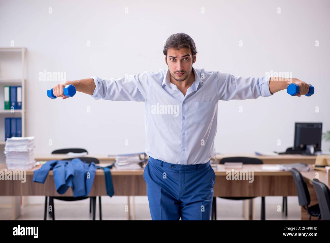 Young employee doing sport exercises during break Stock Photo - Alamy