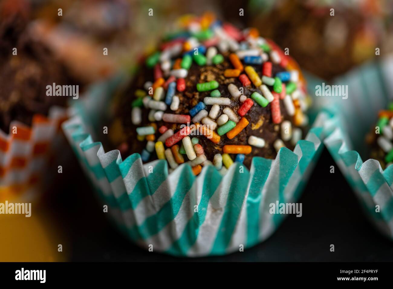 Closeup shot of rainbow sprinkle munchkins on paper muffin cups Stock ...