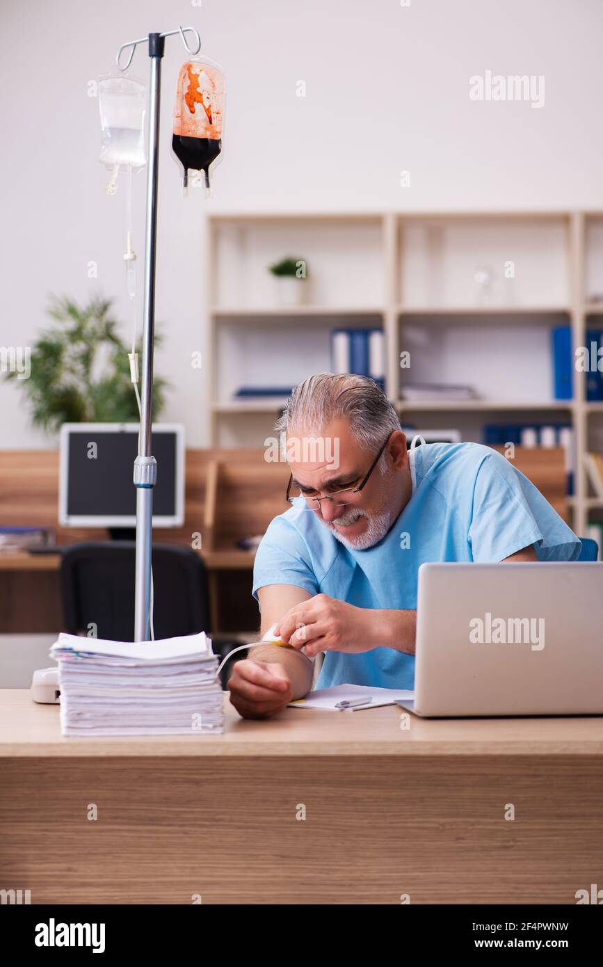Old businessman employee in blood transfusion concept Stock Photo - Alamy