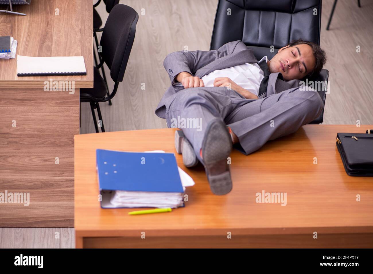 Young employee sleeping at workplace Stock Photo - Alamy