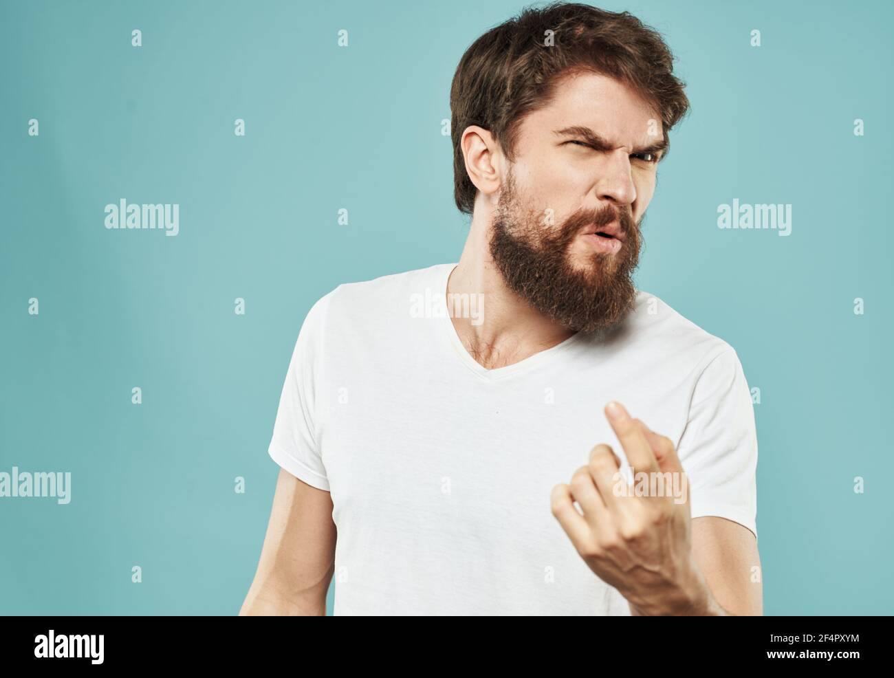Aggressive man on blue background shows forefinger stress irritability ...