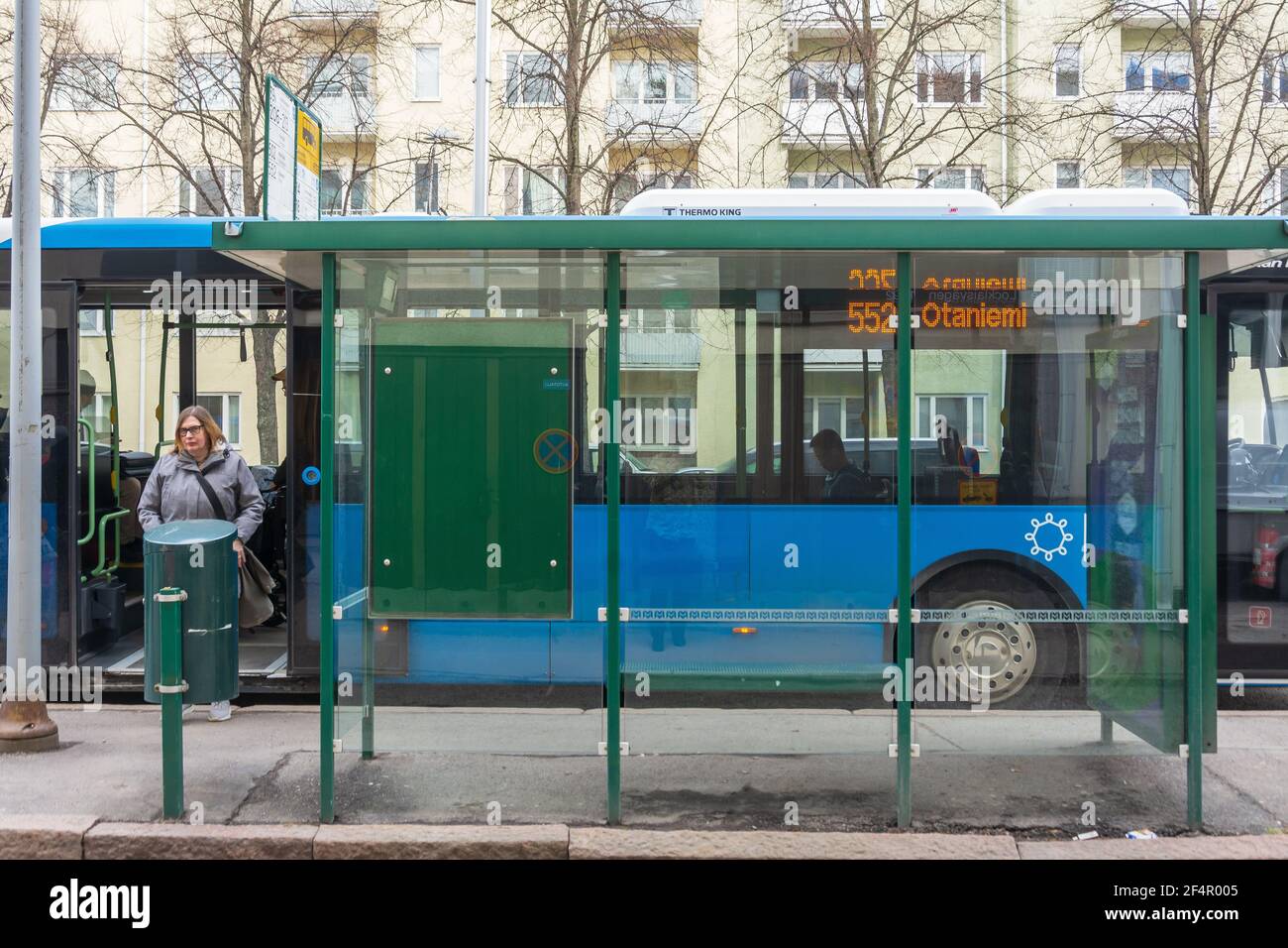 Woman stepping out of a local bus at bus stop in Helsinki Finland Stock ...