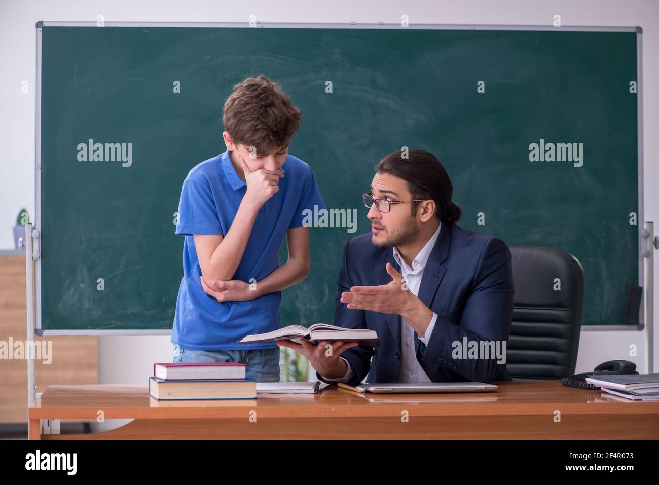 Male teacher and schoolboy in the classroom Stock Photo - Alamy