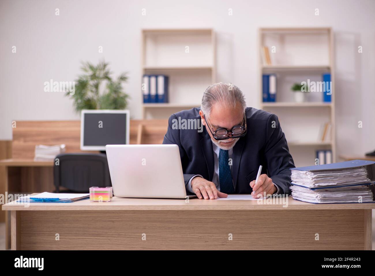 Old employee auditor wearing many glasses at workplace Stock Photo - Alamy