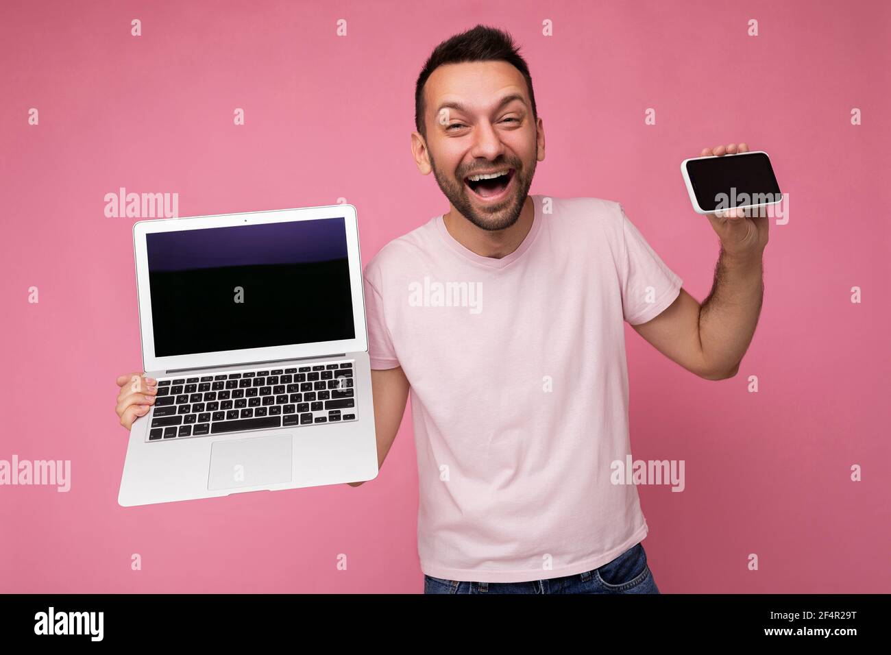 Handsome laughing and smiling brunet man holding laptop computer and ...