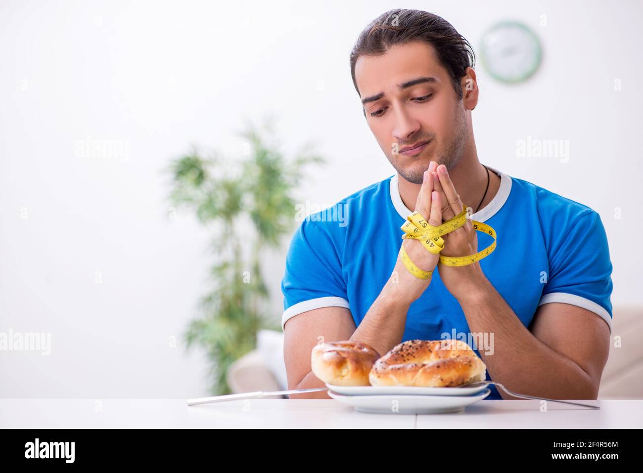 Young hungry man in the dieting concept Stock Photo - Alamy