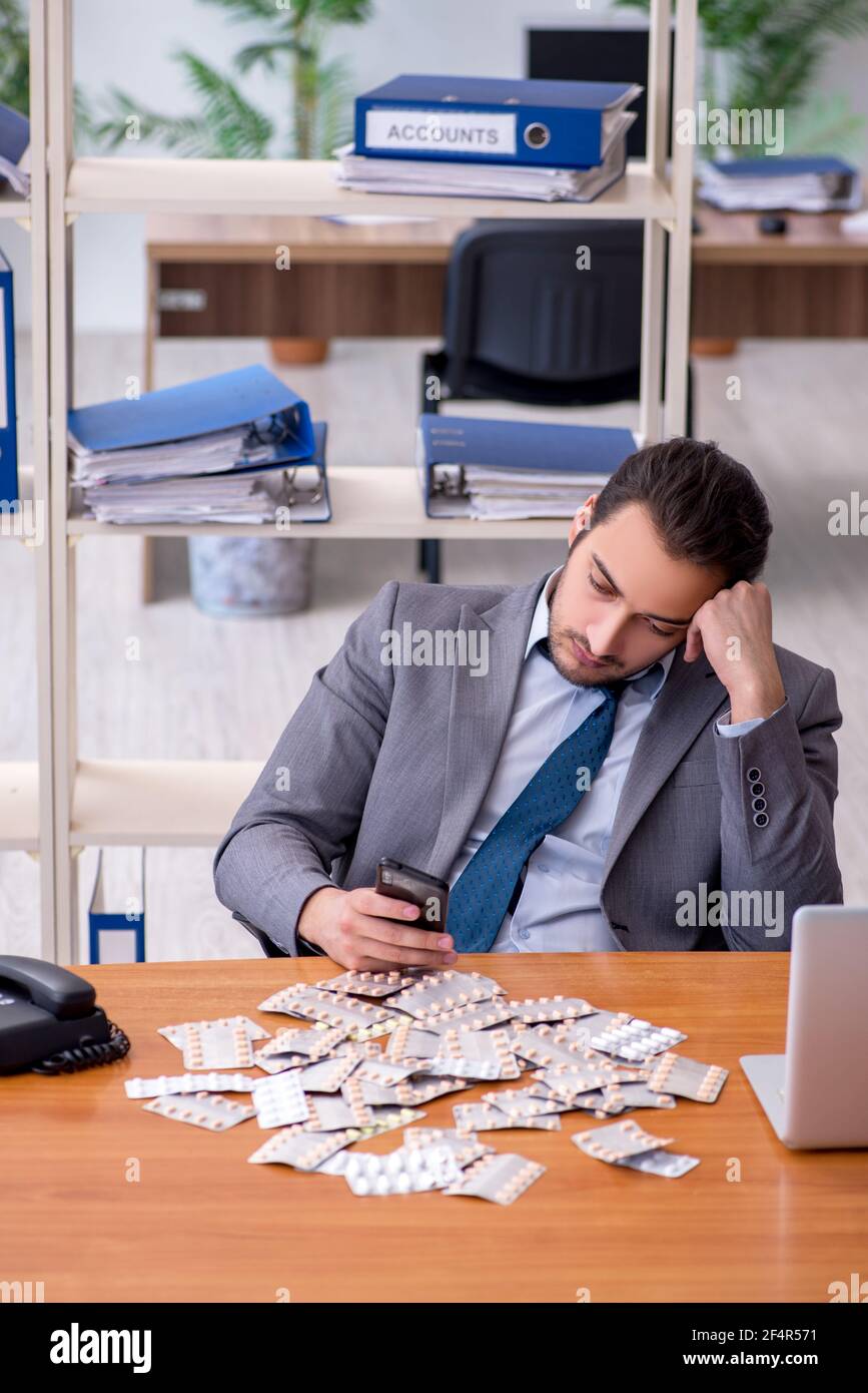 Male sick employee suffering at workplace Stock Photo - Alamy