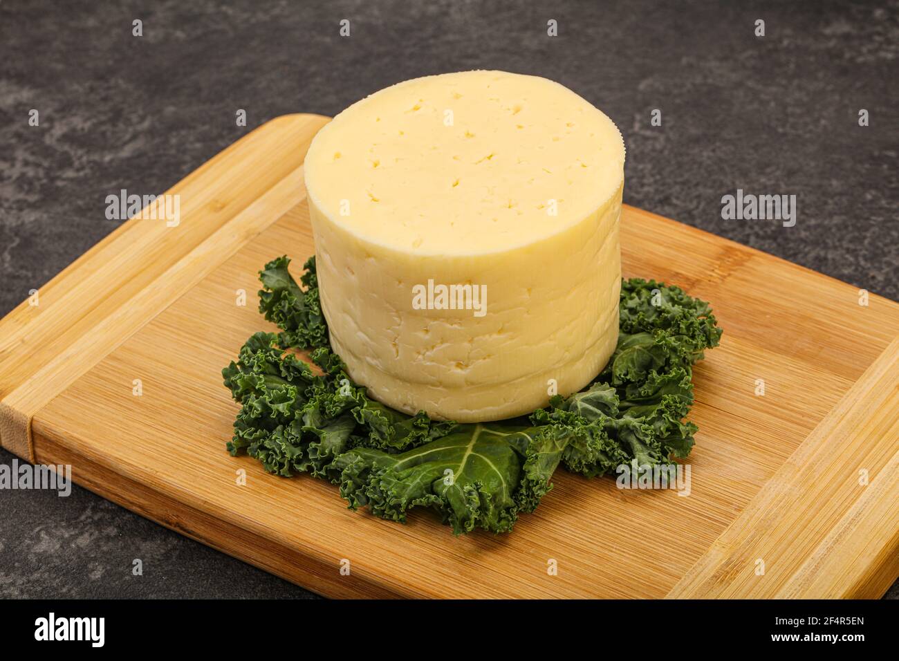 Yellow round dairy soft cheese piece Stock Photo - Alamy