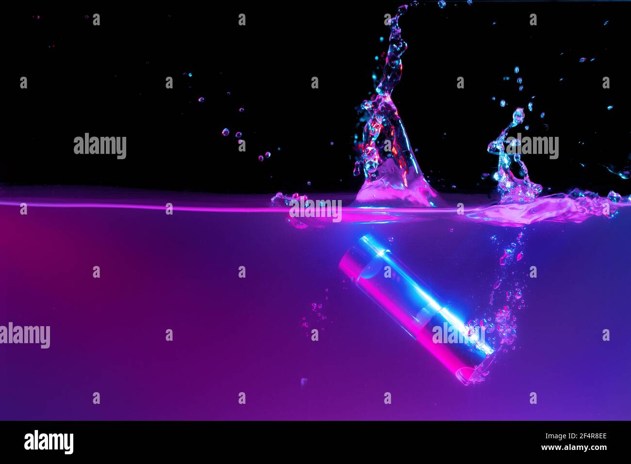 Skincare product bottle falling into water against black background in ...