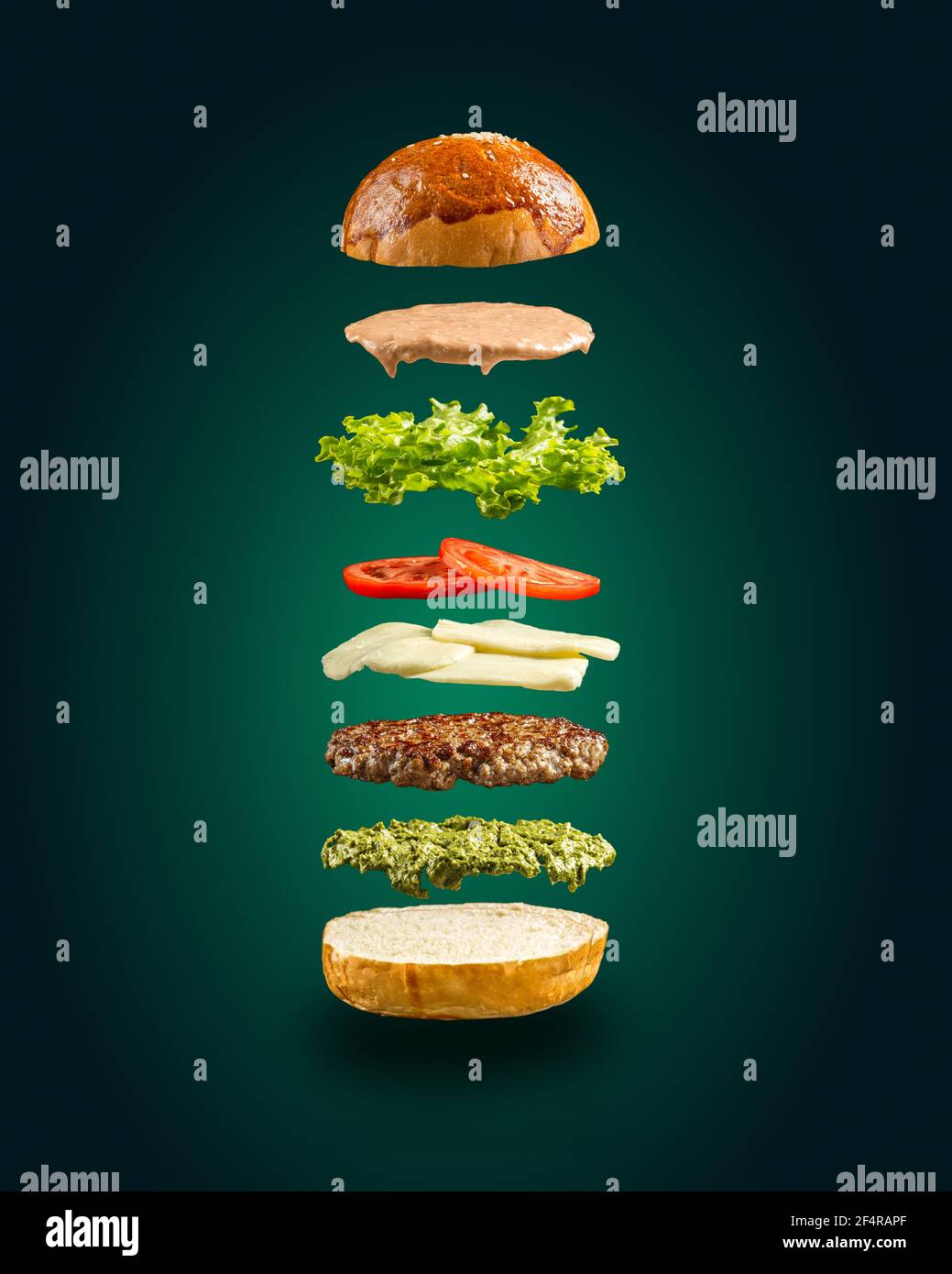 Floating burger ingredients on the green background Stock Photo - Alamy