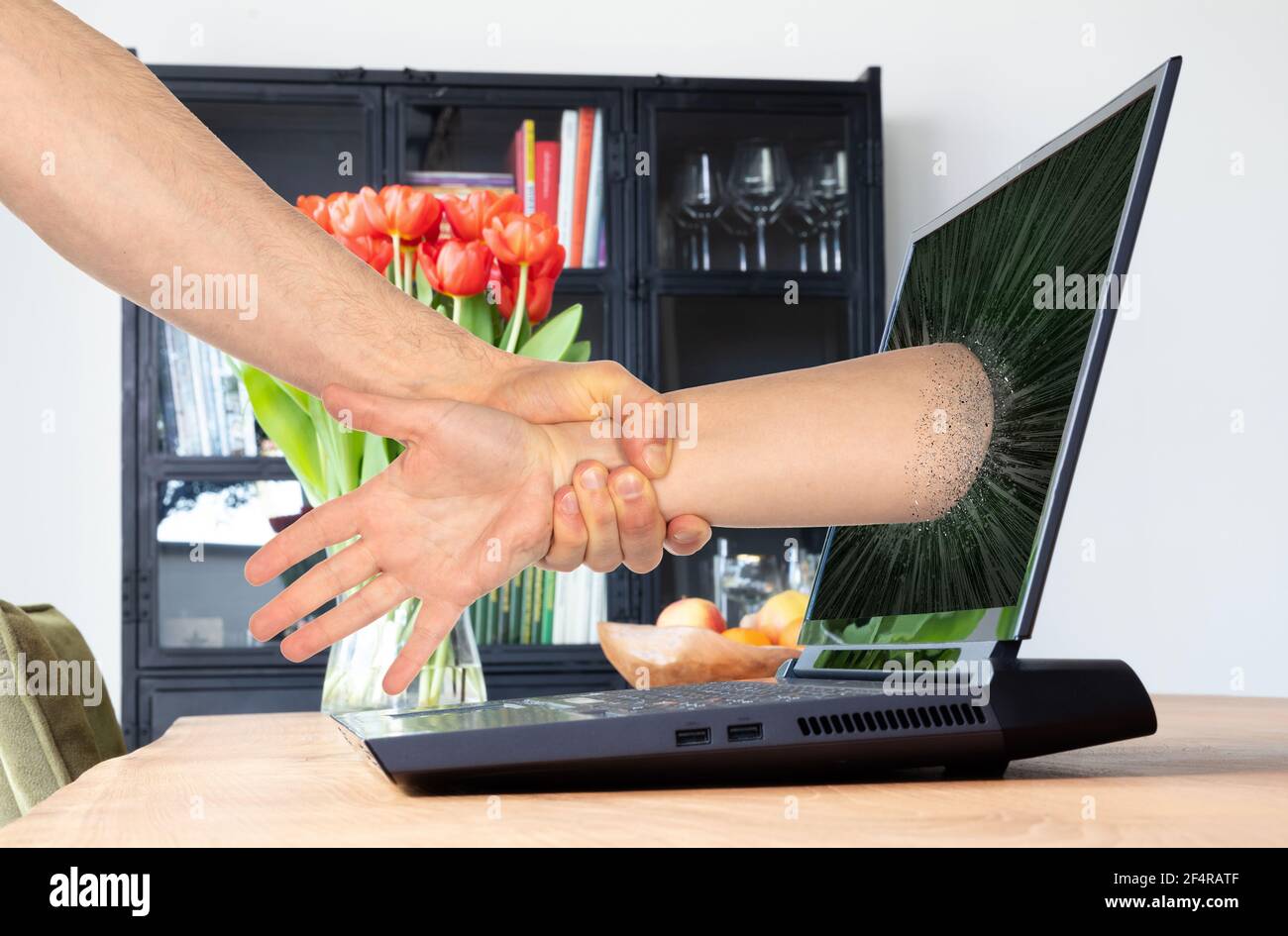 Man pulling someone through the laptop screen, living room background ...