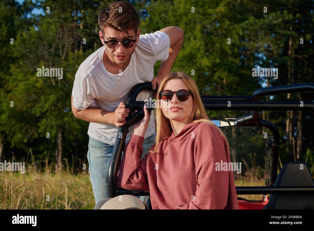 couple enjoying beautiful sunny day while driving a off road buggy ...