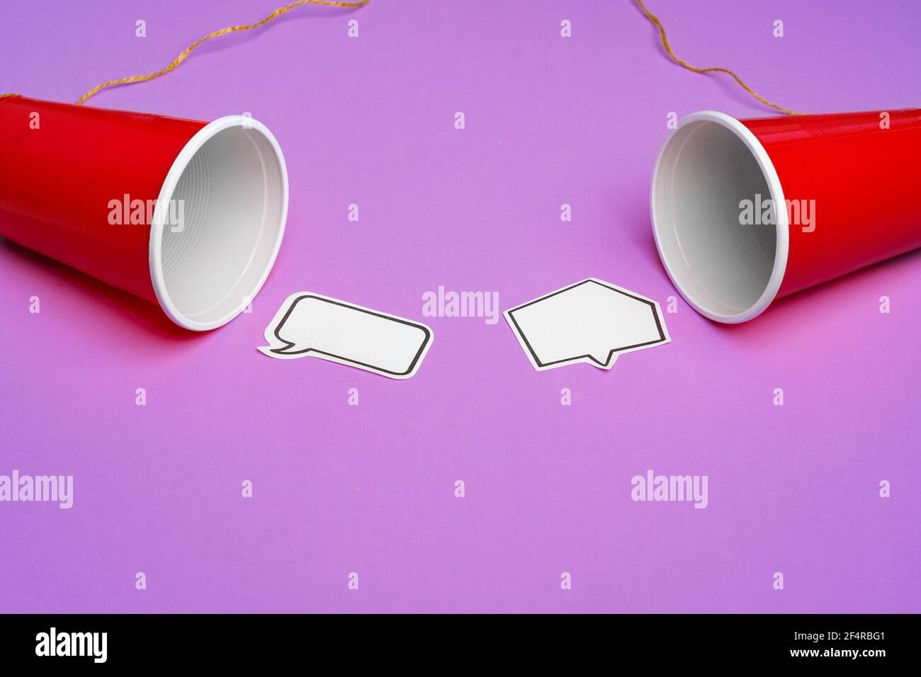 Toy telephone made of plastic cups and string with speech bubbles on ...