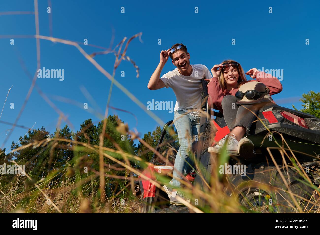 couple enjoying beautiful sunny day while driving a off road buggy ...