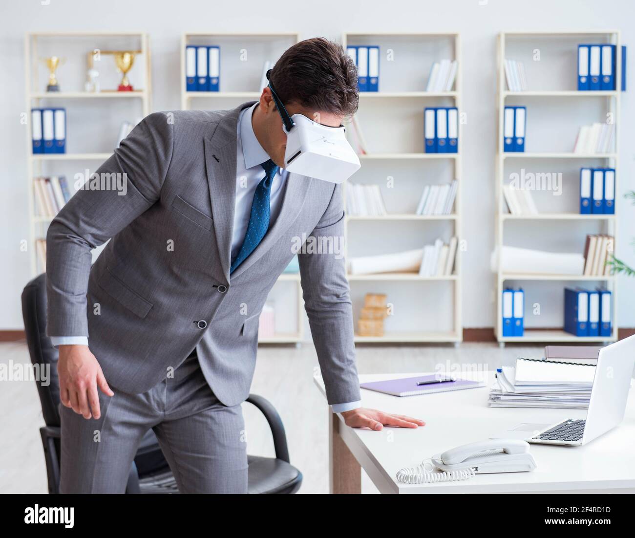 The businessman exercising in office wearing vr glasses Stock Photo - Alamy