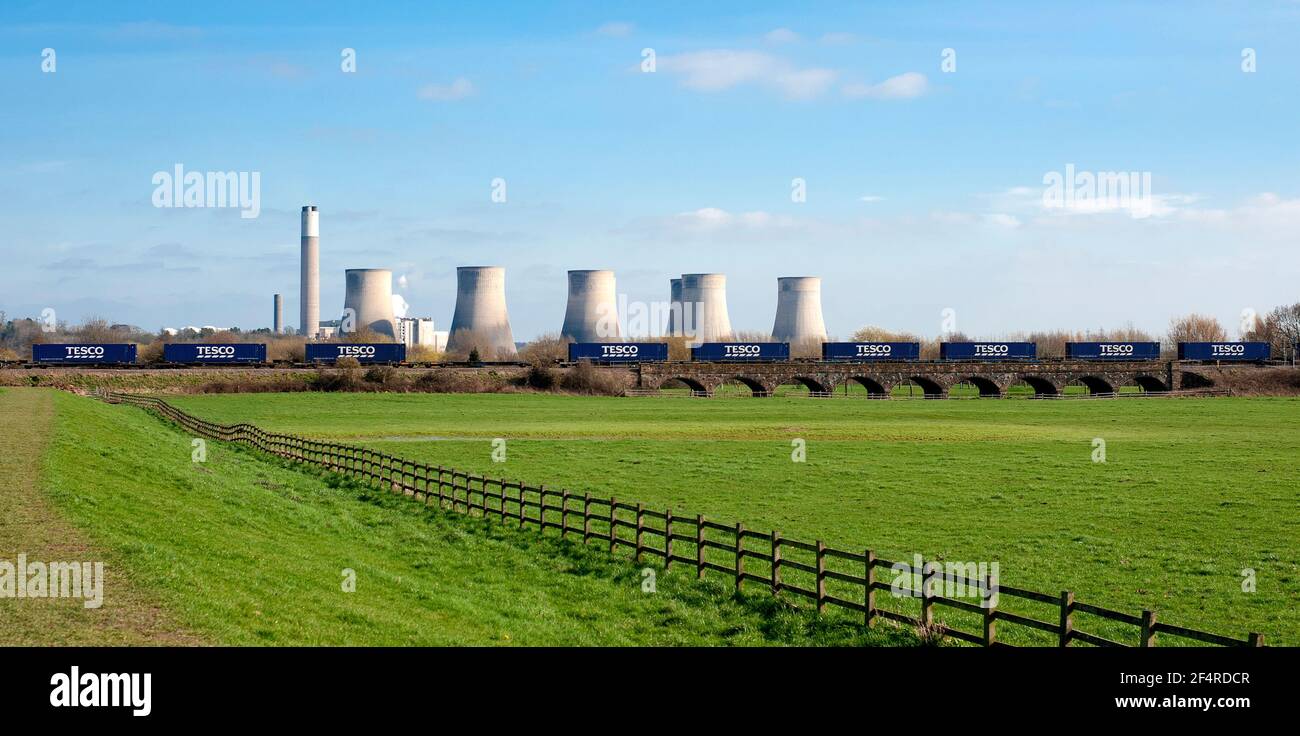 Long train of goods wagons with a power station in the background Stock ...
