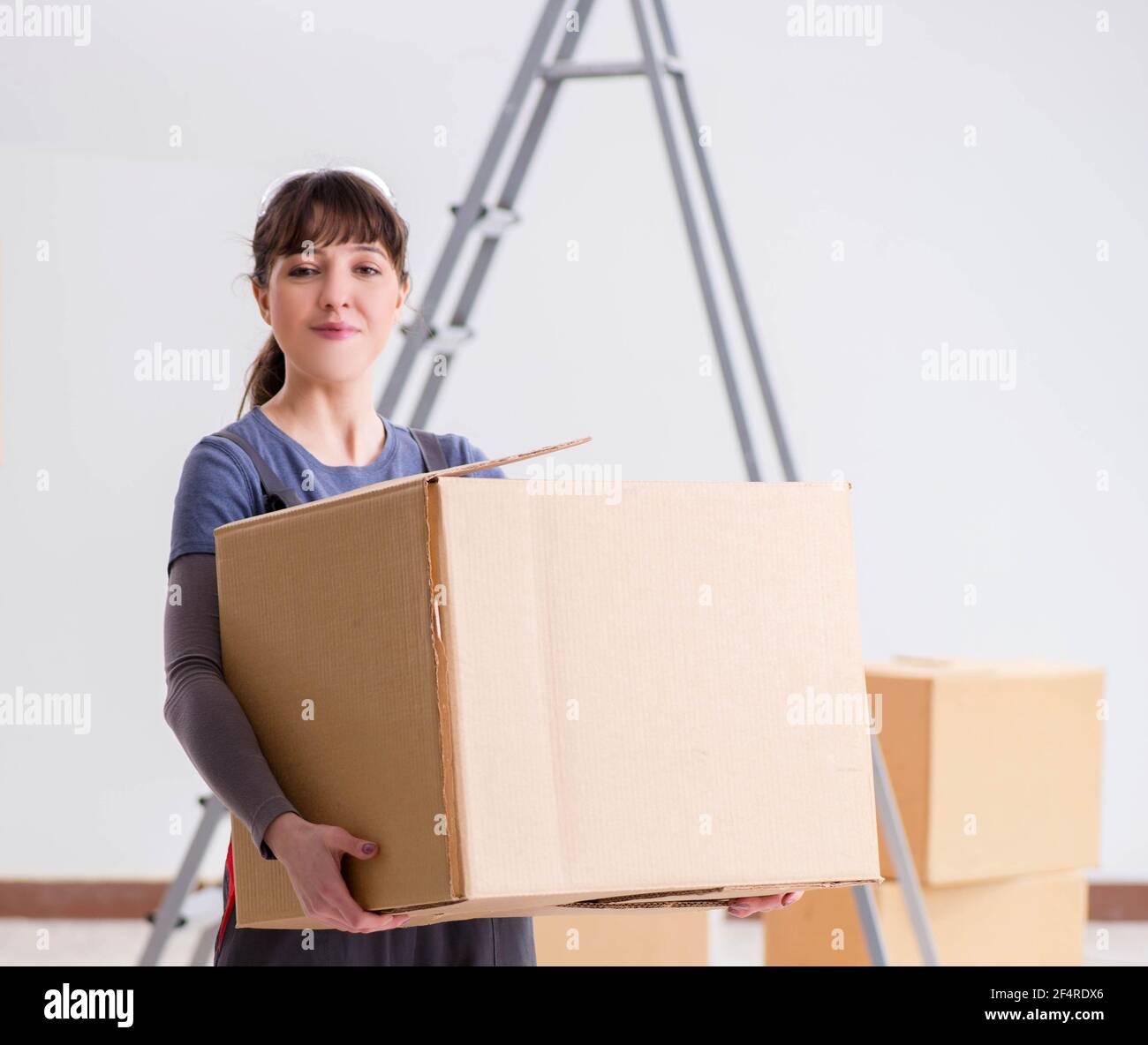 The woman contractor moving boxes in relocation concept Stock Photo - Alamy