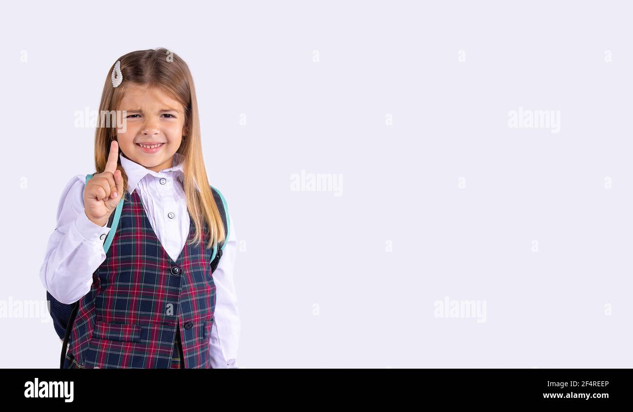 Studio photo of a primary school girl in a school uniform. Smiles and ...