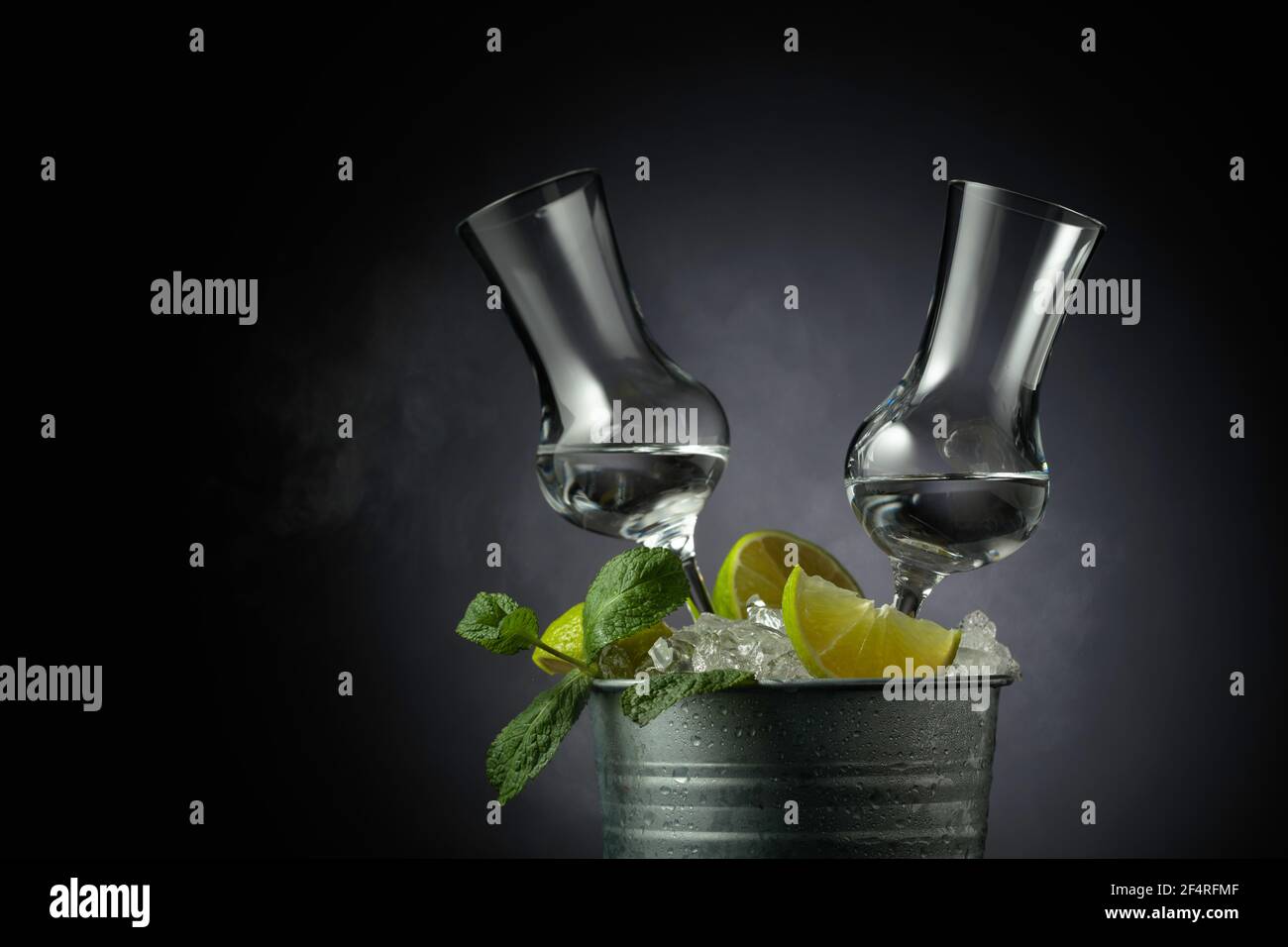 Strong alcoholic drink with lime and mint in a metal bucket with ice ...
