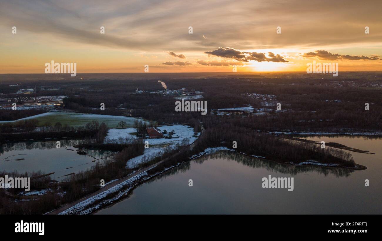 Aerial view of a beautiful and dramatic sunset over a forest lake ...