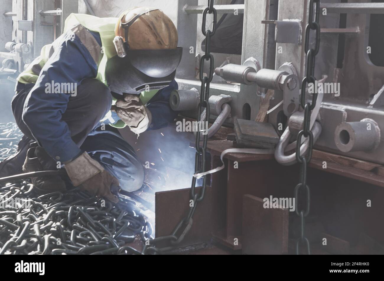 Welder doing welding on deck of ship lashing cargo for sea shipping on ...