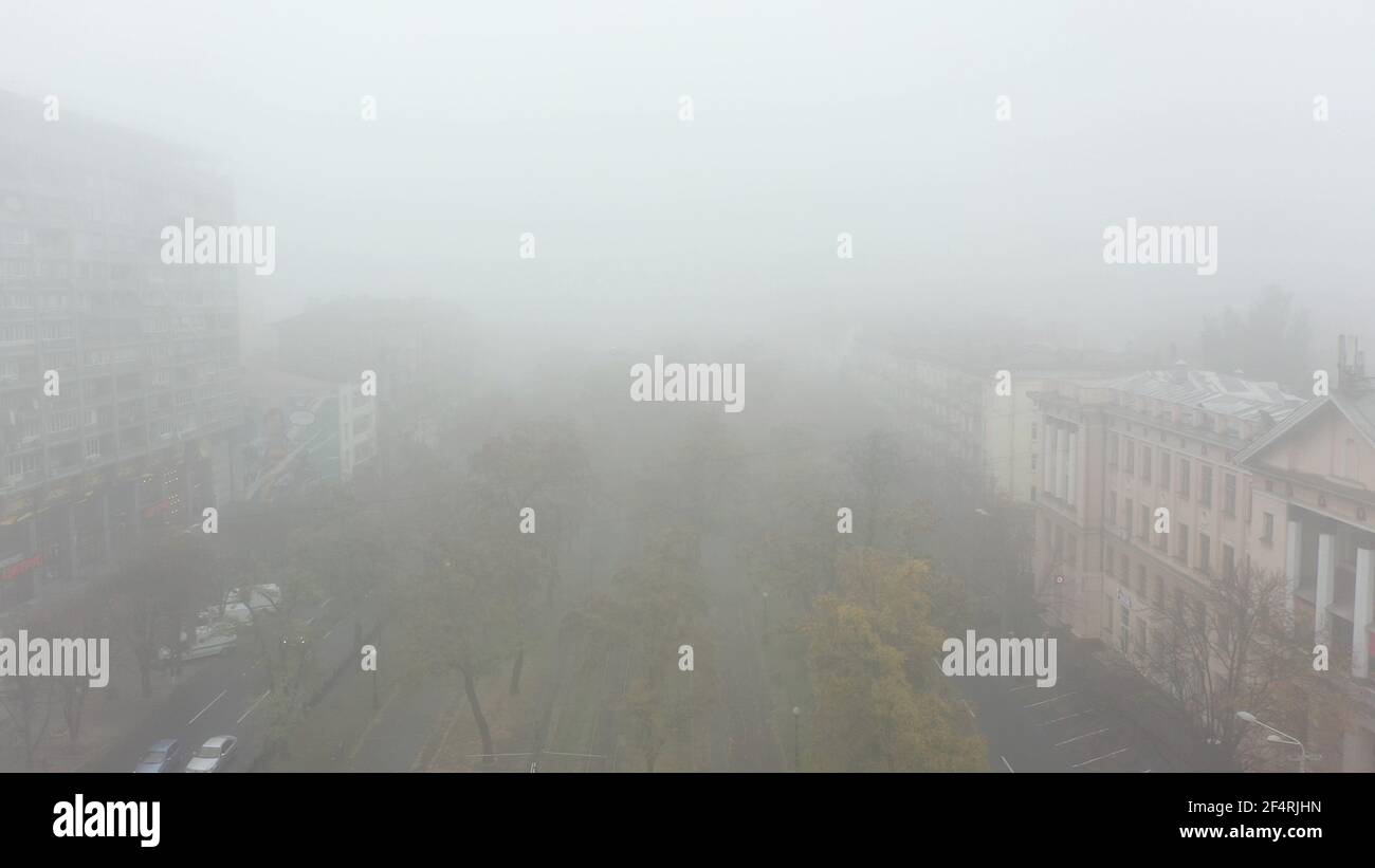 Urban landscape. Foggy cityscape. Foggy city street with silhouettes of ...