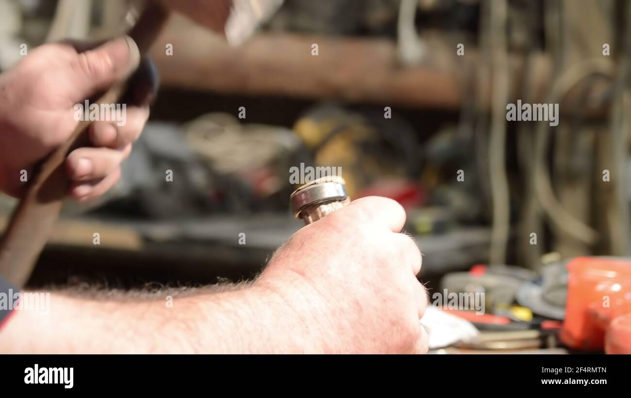 carpenter with hammer and chisel processing wood plank at workshop ...