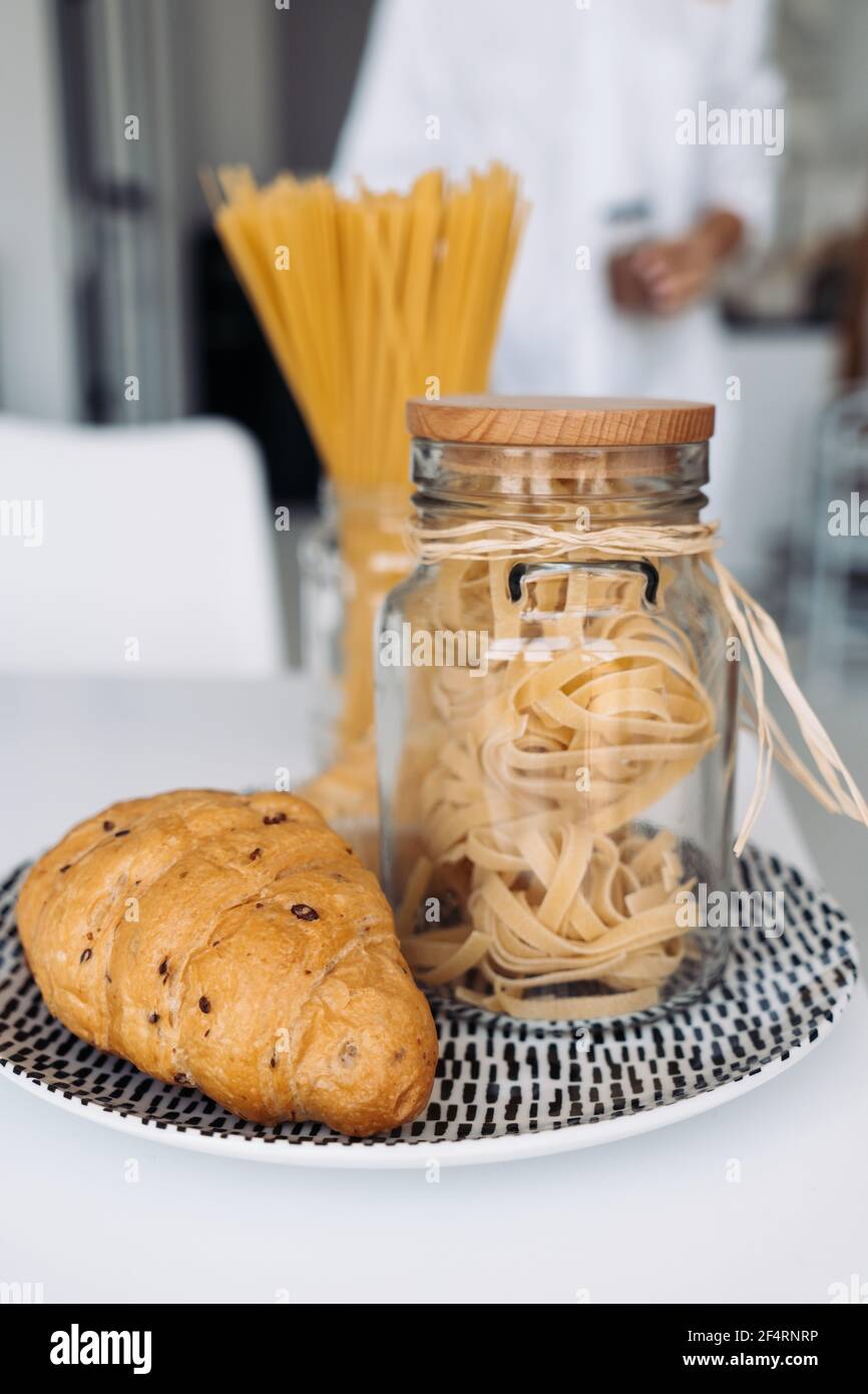 Croissant and pasta food group on kitchen background Stock Photo - Alamy