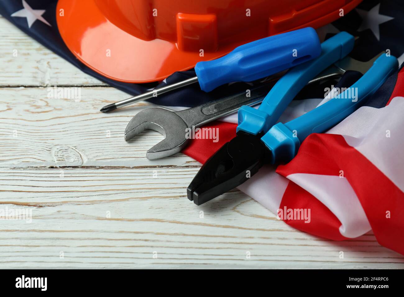 American flag, hard hat and tools on white wooden background Stock ...