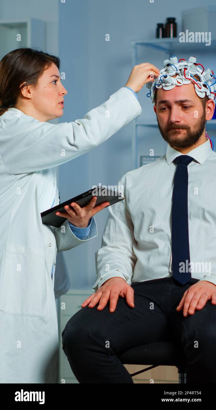 Man with brainwave scanning headset visiting professional doctor ...