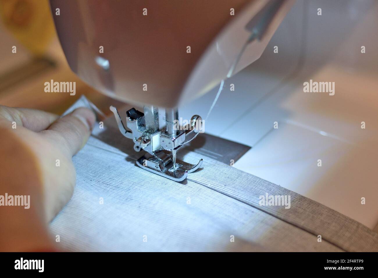 Sewing machine during work. Needle, grey fabric and woman's hand Stock ...