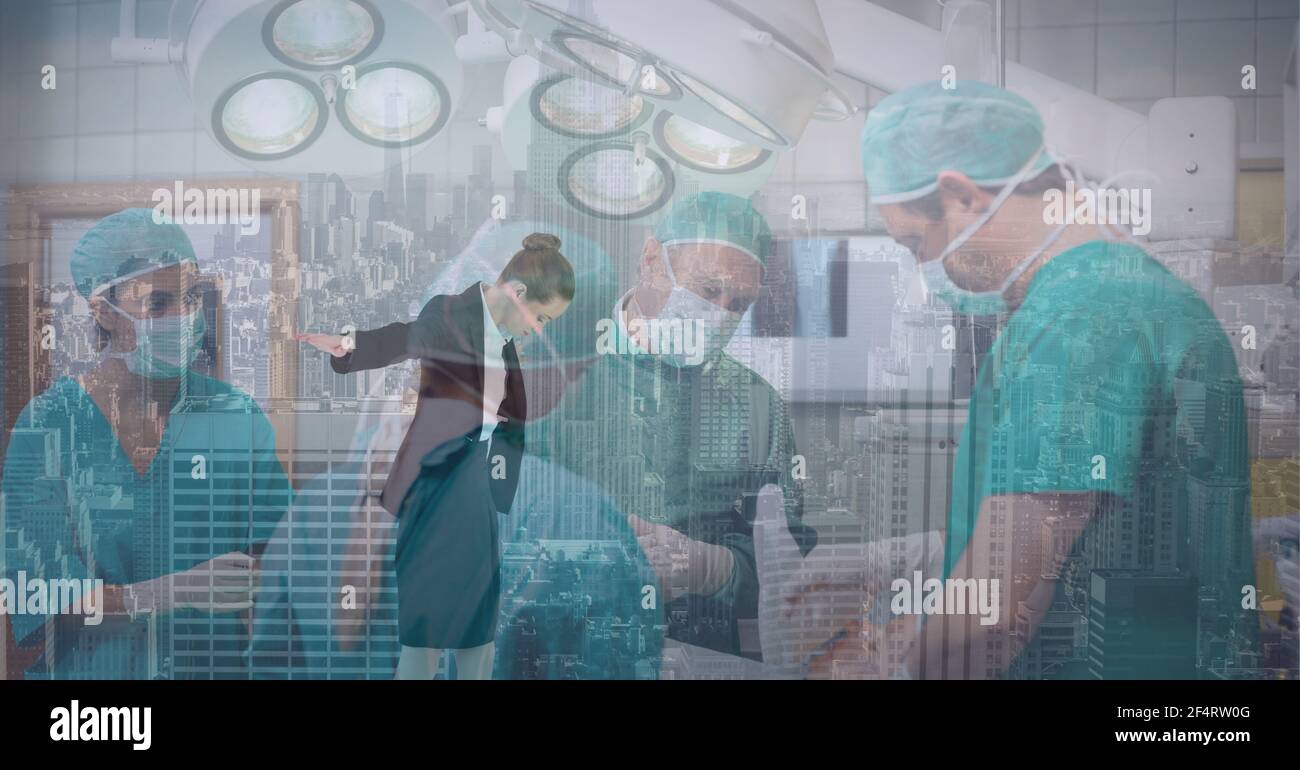 Team of surgeons performing operation at hospital against cityscape in ...