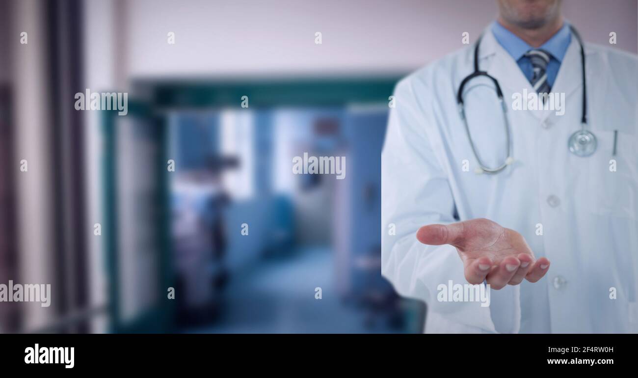 Mid section of male doctor with cupped han standing at hospital Stock ...