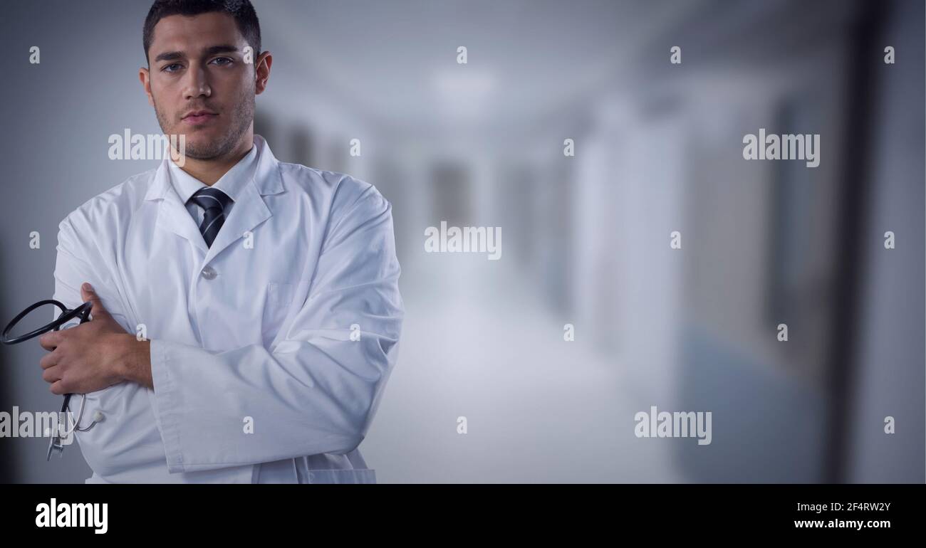 Portrait of caucasian male doctor with arms crossed standing at ...