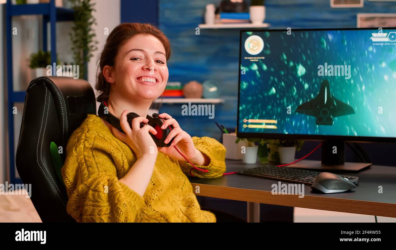 Professional esport woman gamer looking at camera smiling while compete ...