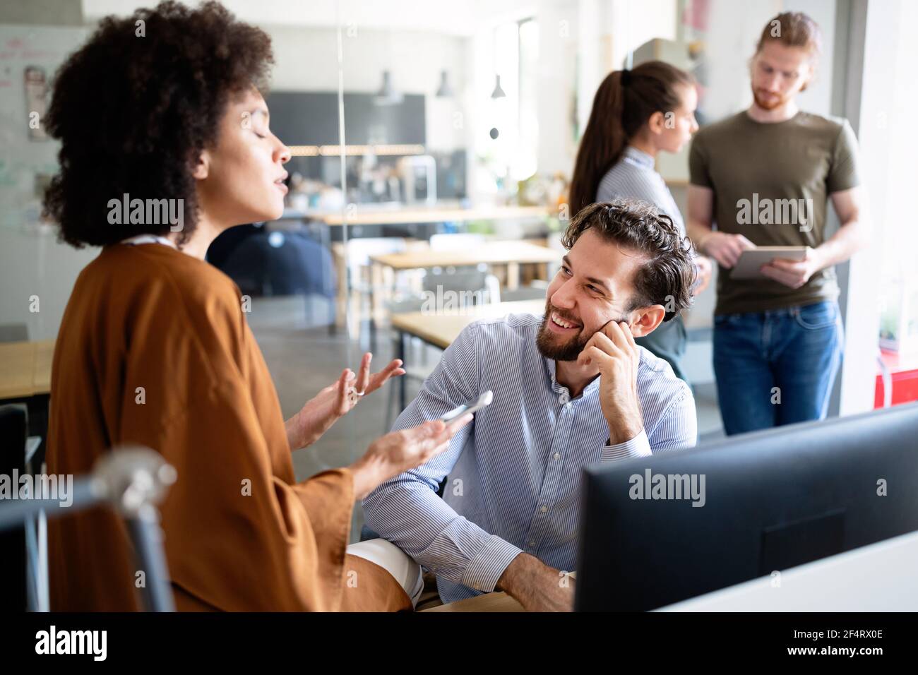 Happy cheerful business colleagues talking in modern IT office Stock ...