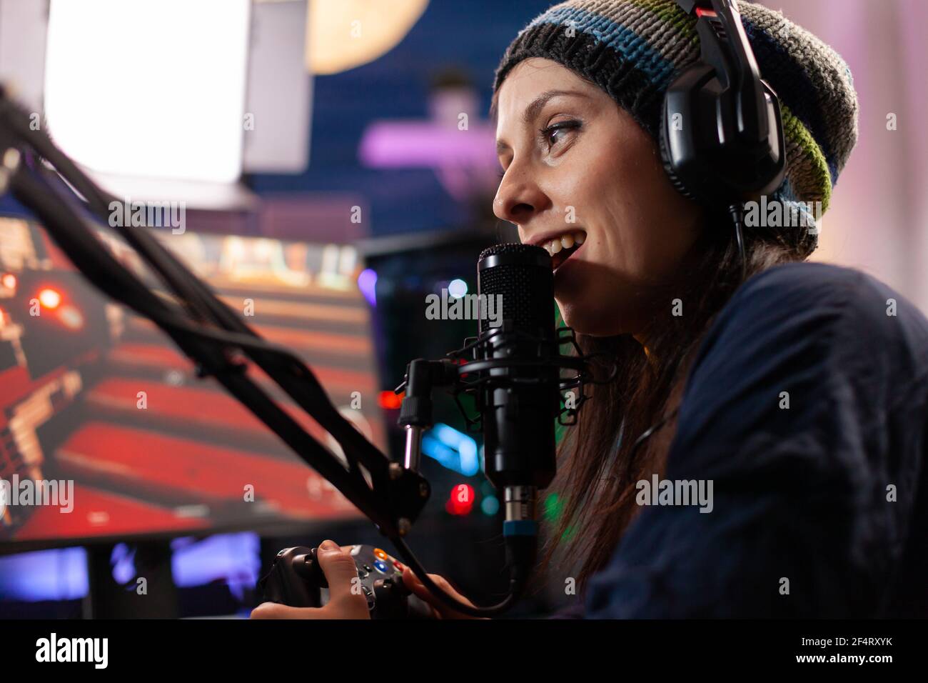 Close up of streamer woman talking into professional microphone in home ...
