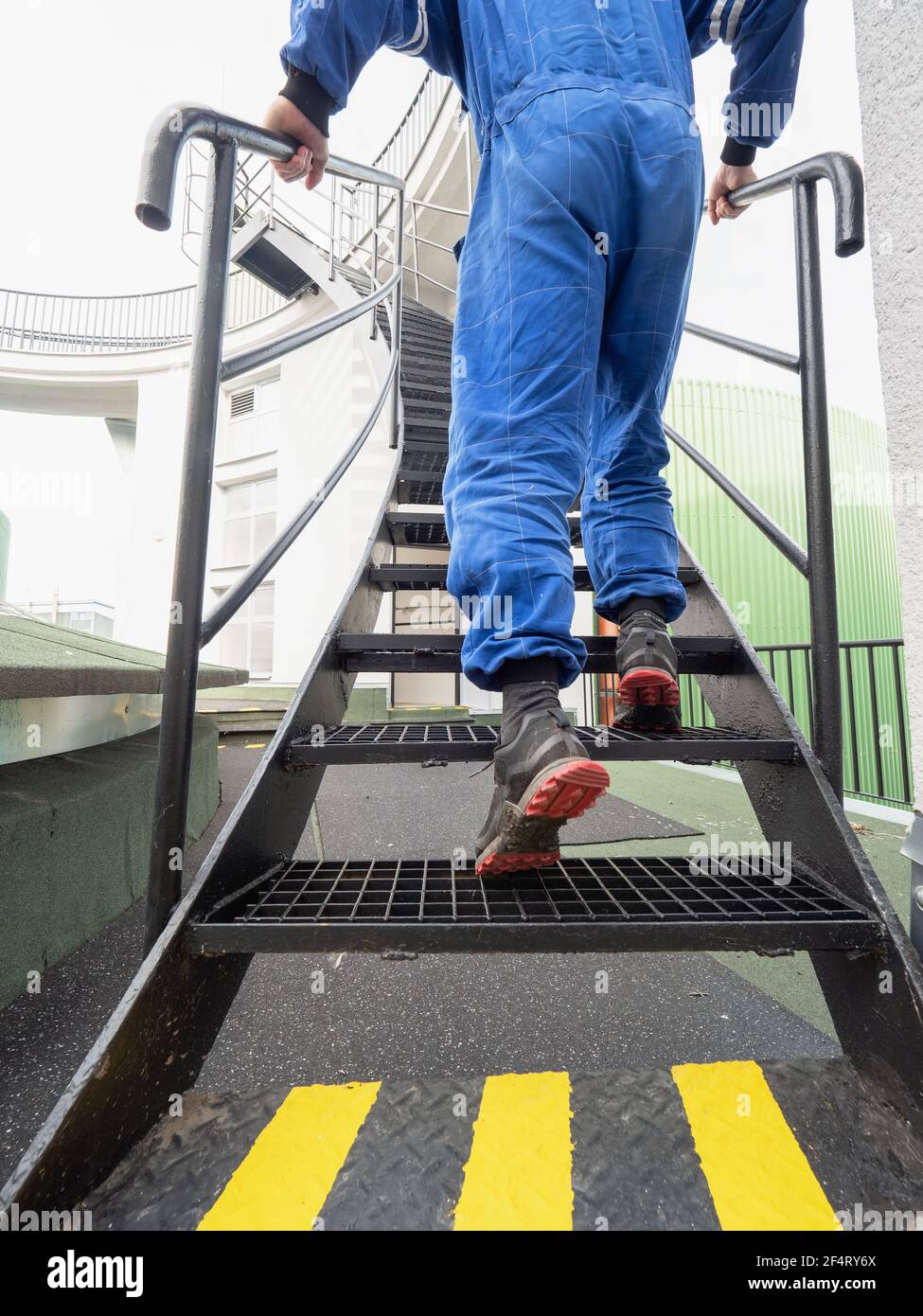 Worker on staircase. Low angle view of industrial man engineer climbing ...
