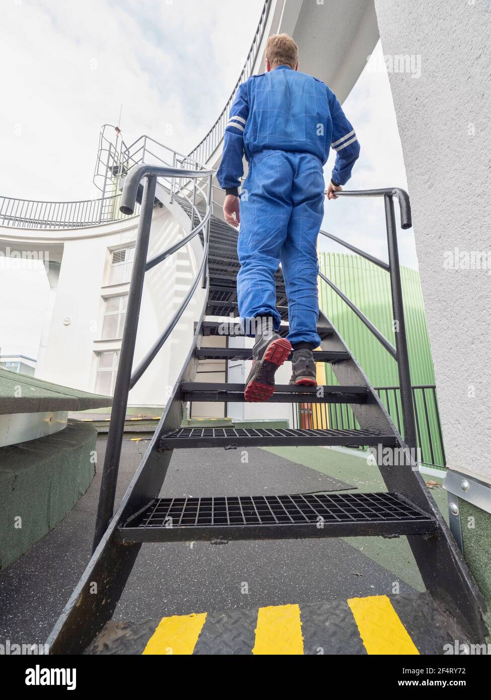 Employee walk upstairs in factory. Man in safety wearing going up on ...