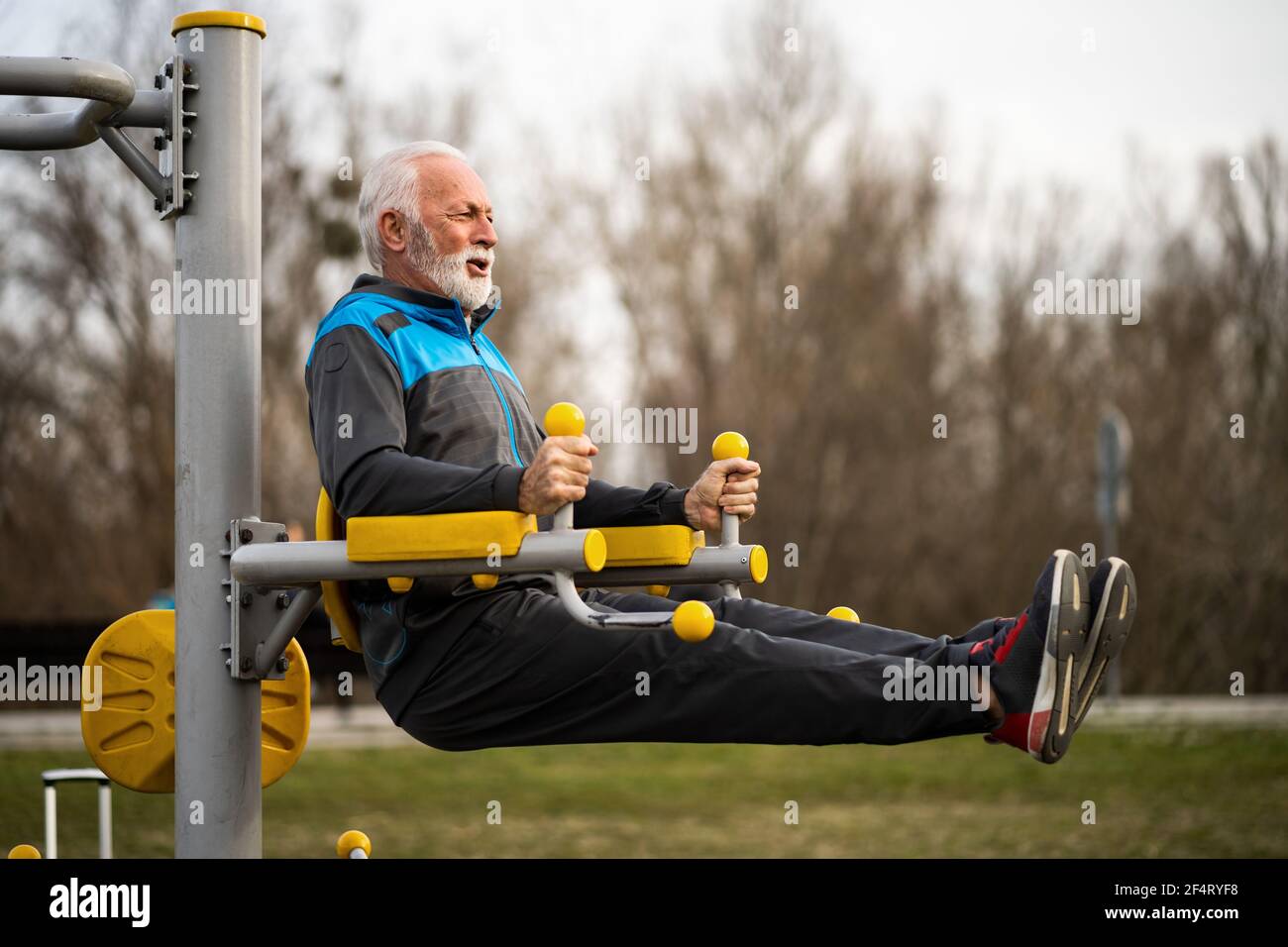 Active senior man is exercising on outdoor gym. Healthy retirement ...