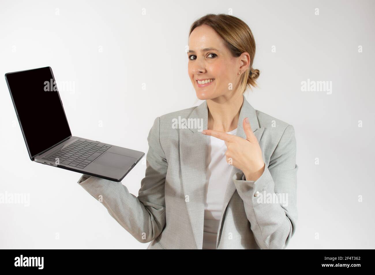 Business young woman holding laptop computer over white background ...