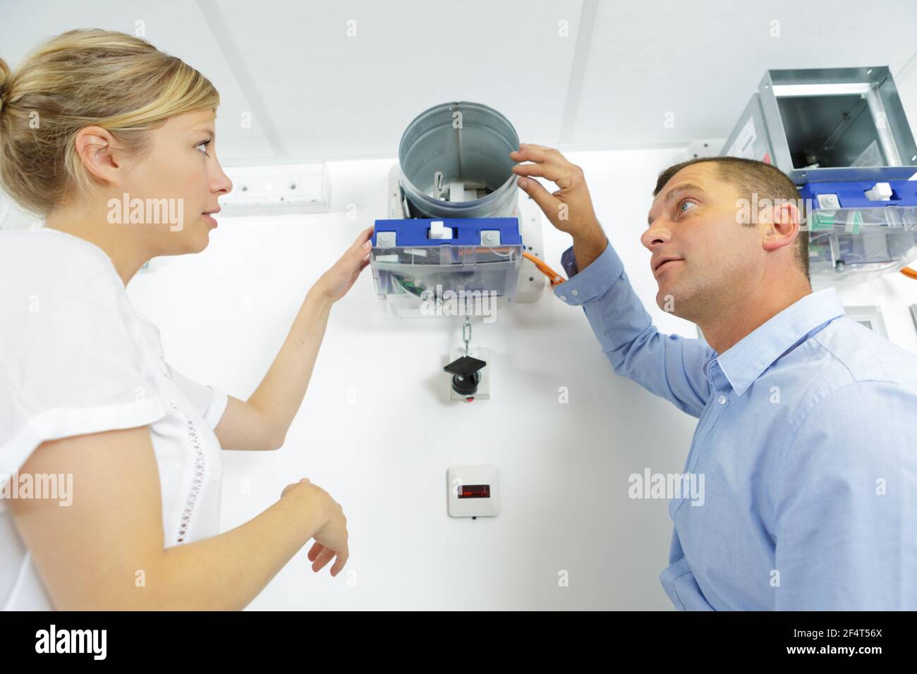 woman man checking pipes in office Stock Photo - Alamy
