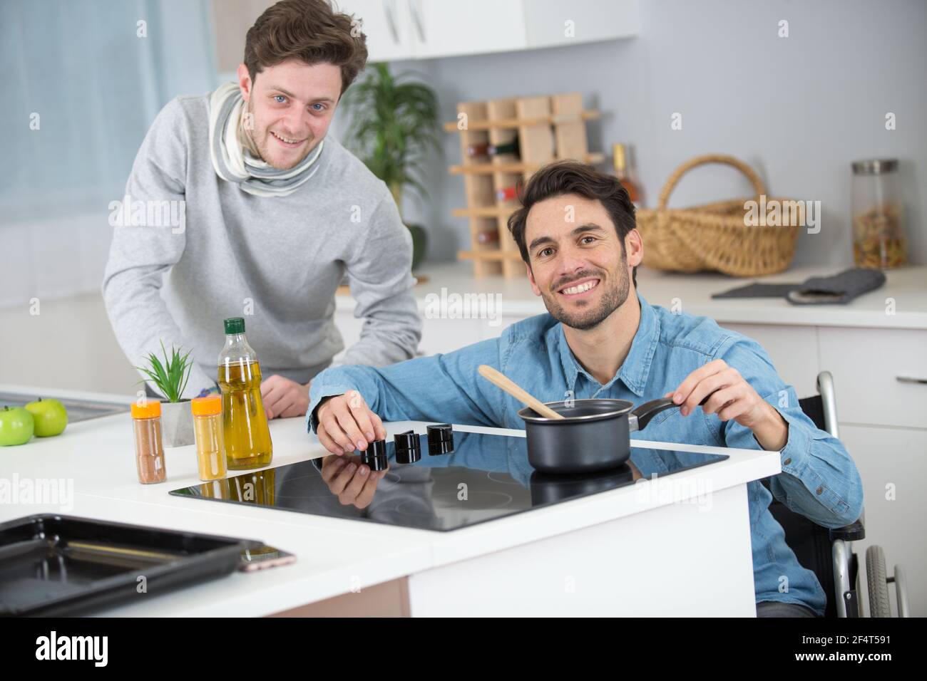 disabled man cooking at home with younger man Stock Photo - Alamy