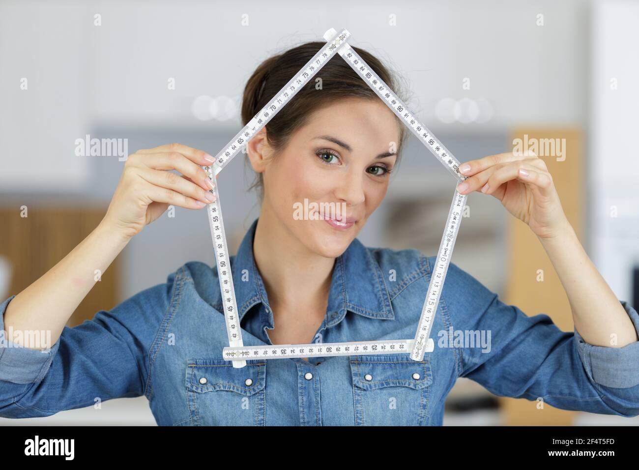 a woman with a house ruler concept Stock Photo - Alamy